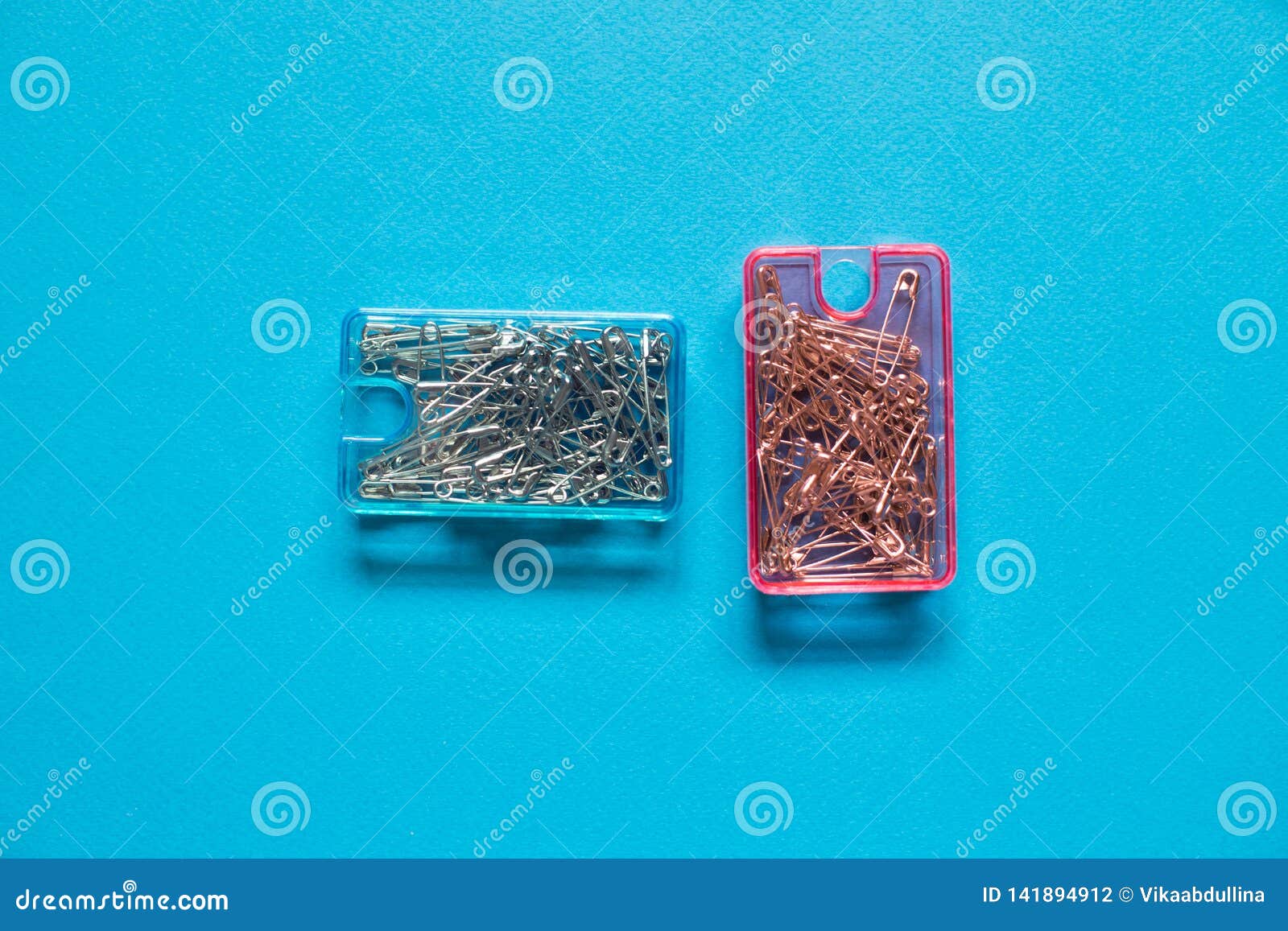 Safety Pins in Blue and Pink Plastic Boxes on Blue Background Stock ...