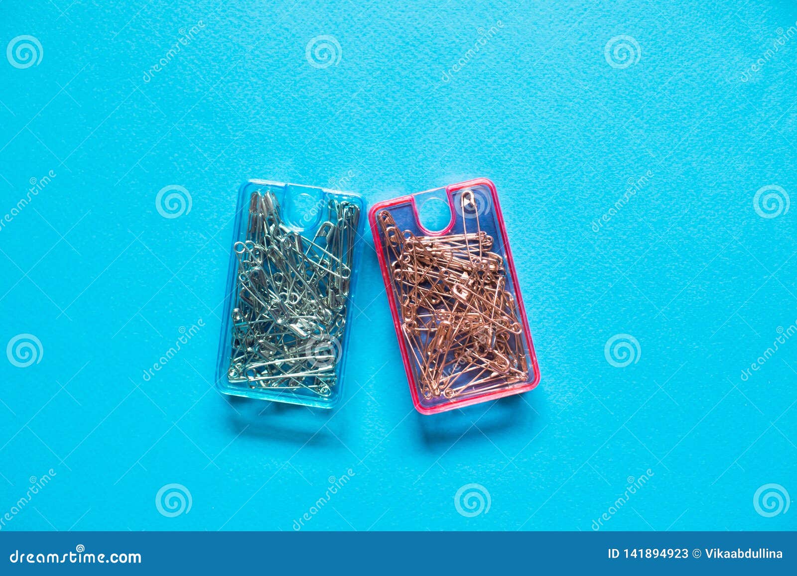 Safety Pins in Blue and Pink Plastic Boxes on Blue Background Stock ...