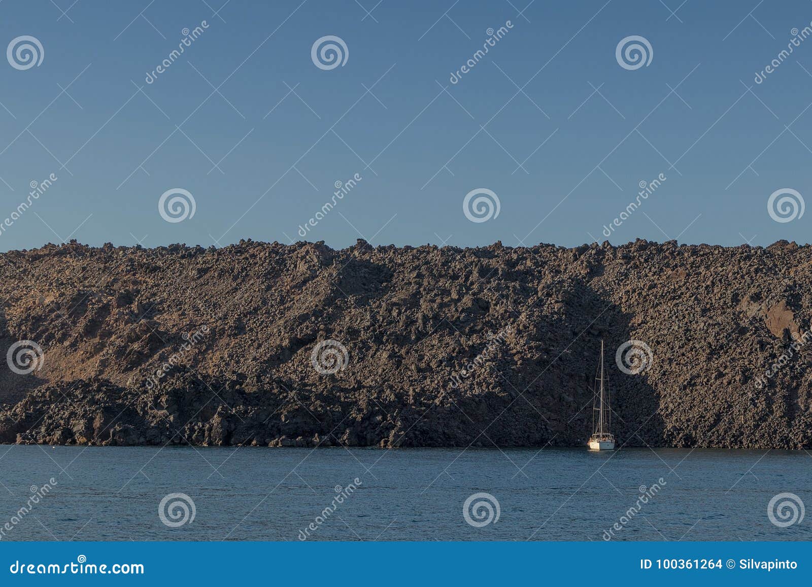 Sailboat with Cliff Behind in the Sea of Santorini. Stock Photo - Image ...