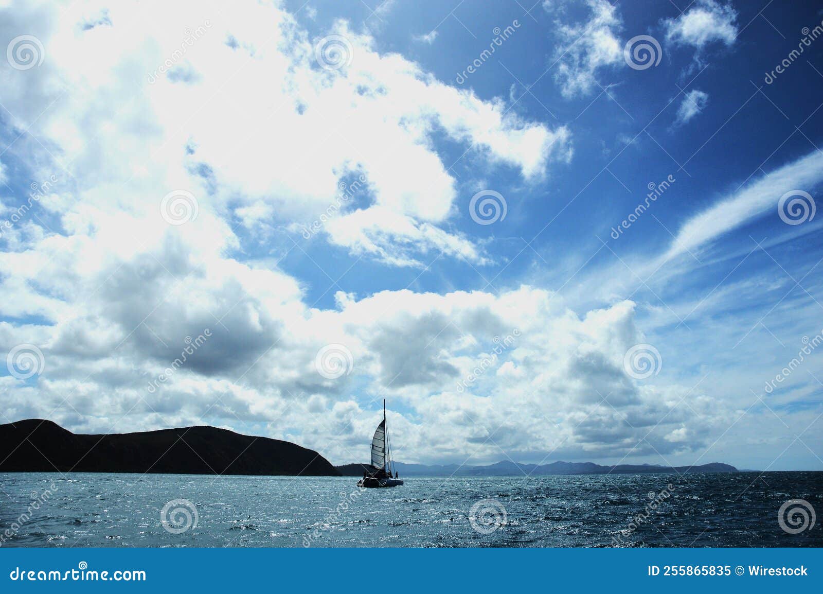 Sailboat Sailing on Blue Water Under a Bright Cloudy Sky Stock Image ...