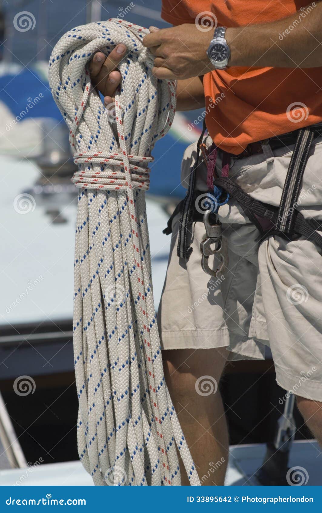 Sailor Tying Ropes on Sailboat Stock Photo - Image of harness, holding ...