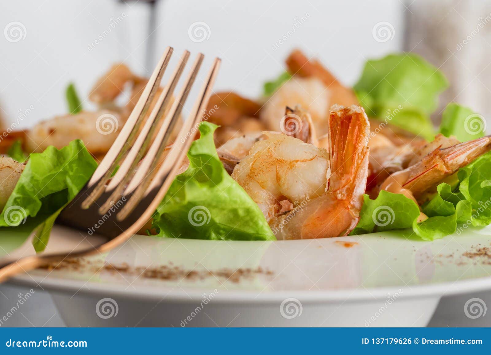 Salad with Royal Prawns on a White Plate on the Dark Surface of the ...