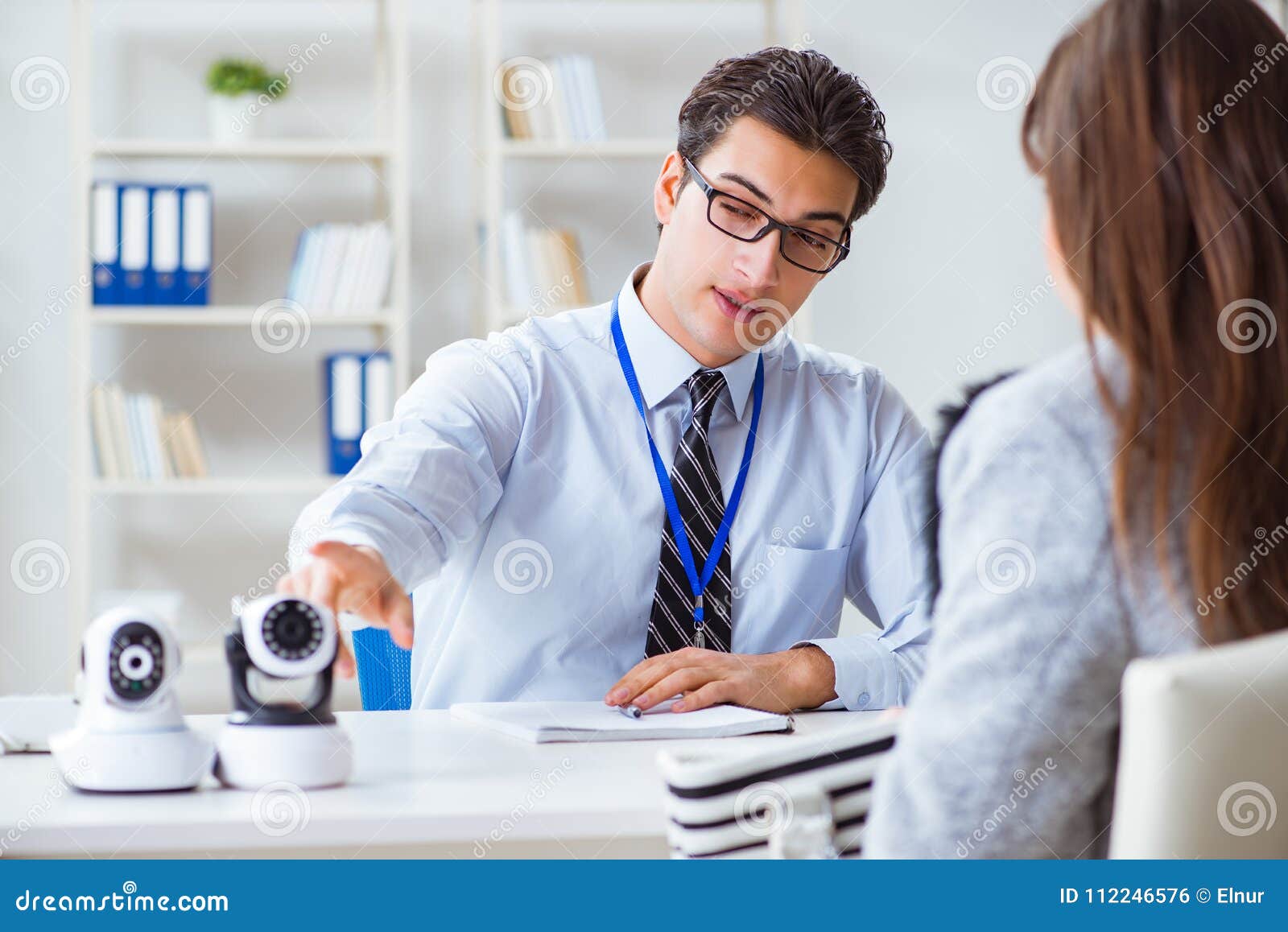 The Sales Assistant Showing Cameras To Client in Shop Stock Photo ...