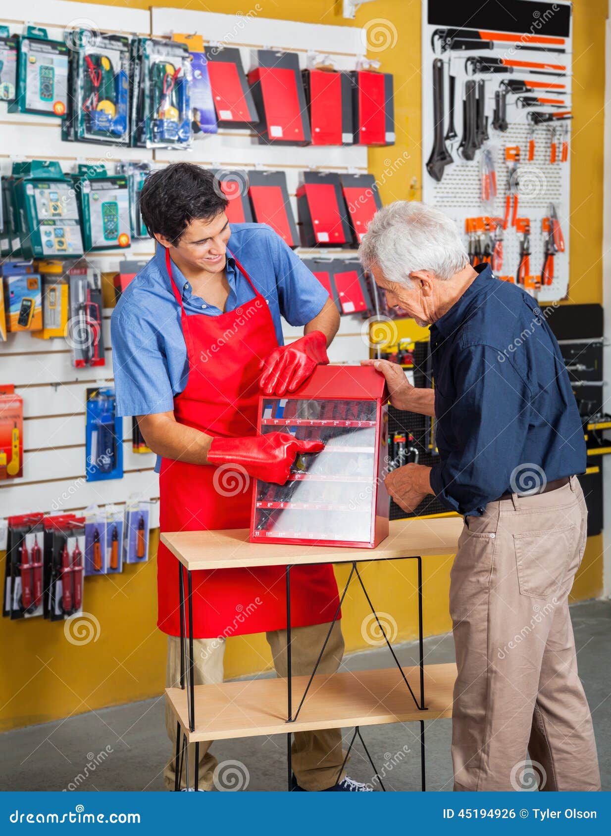 Salesman Guiding Man in Selecting Tools at Store Stock Photo - Image of ...