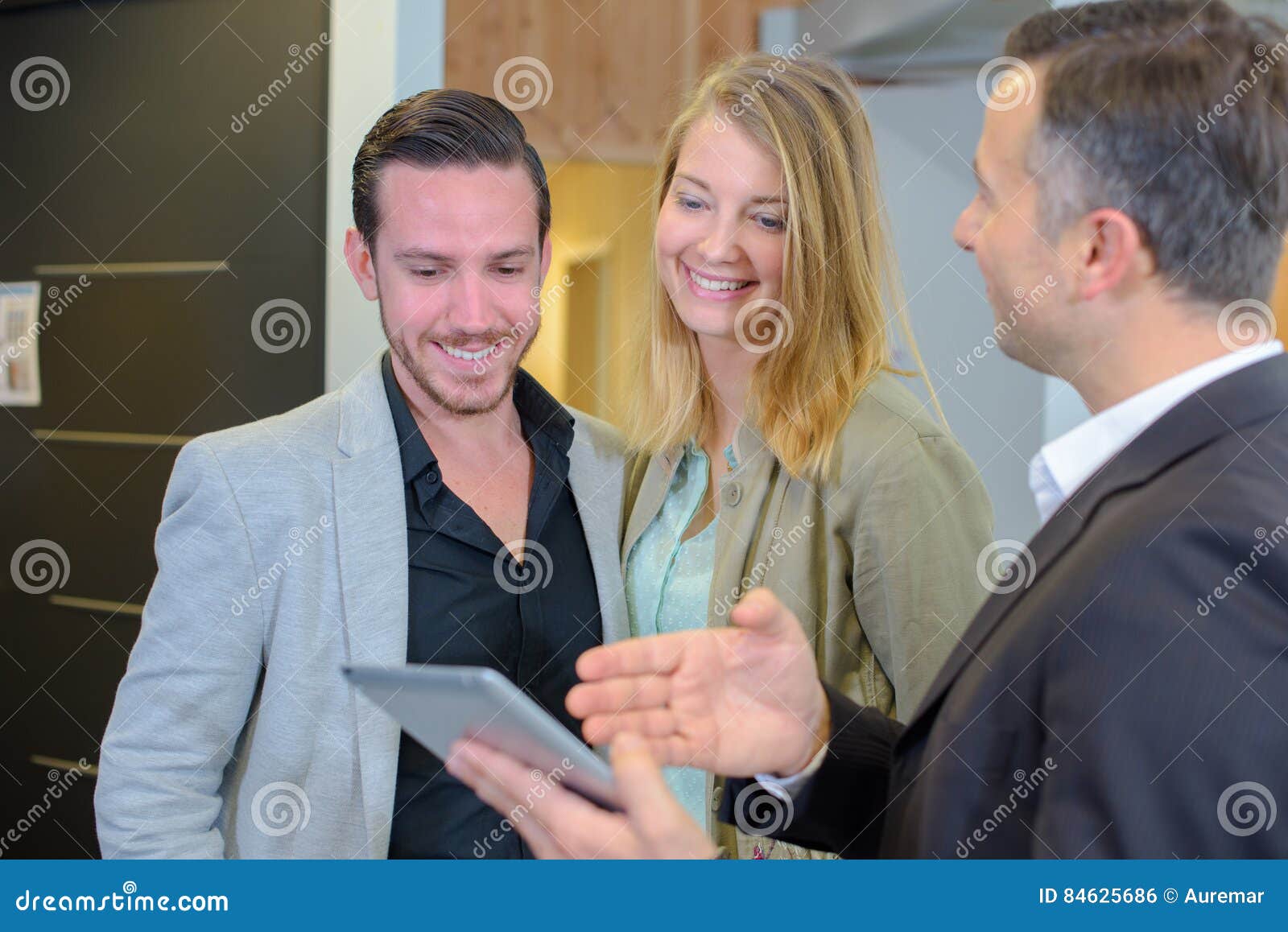 Salesman Showing Screen Tablet To Couple Stock Photo - Image of sales ...