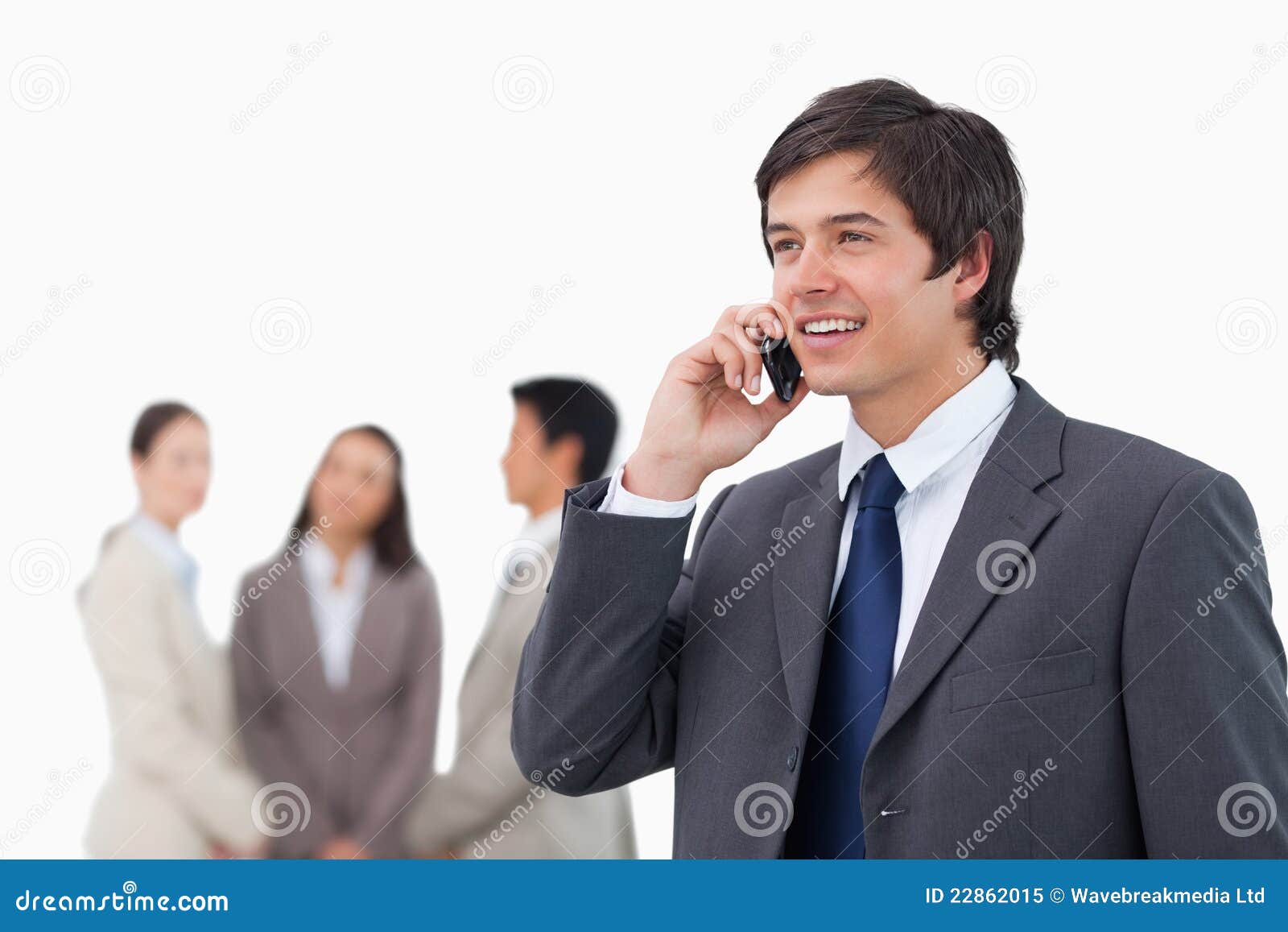 Salesman Talking on Cellphone with Colleagues Behind Him Stock Image ...