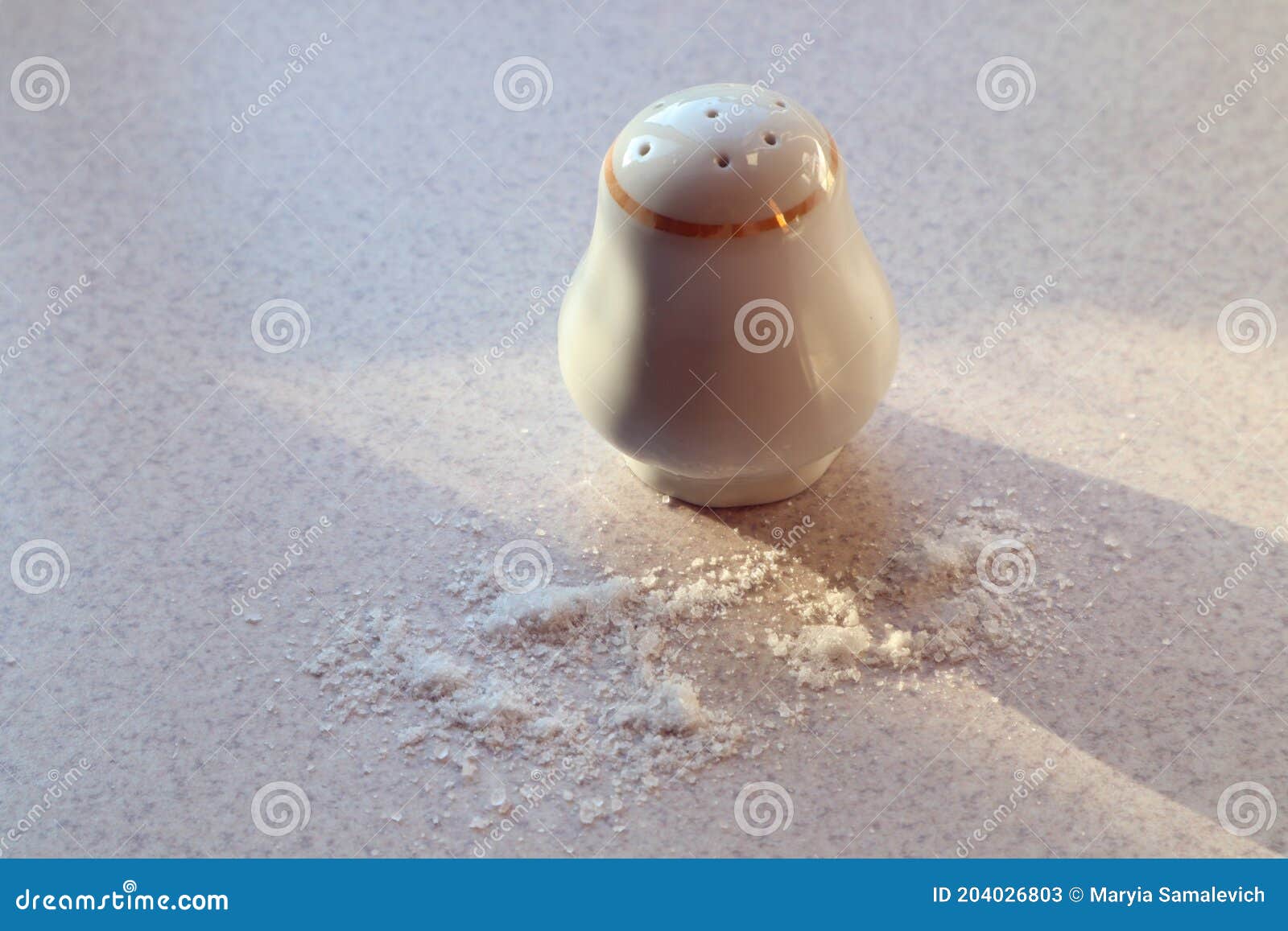Salt in a Dish with Salt Scattered Around it on a Gray Background in ...