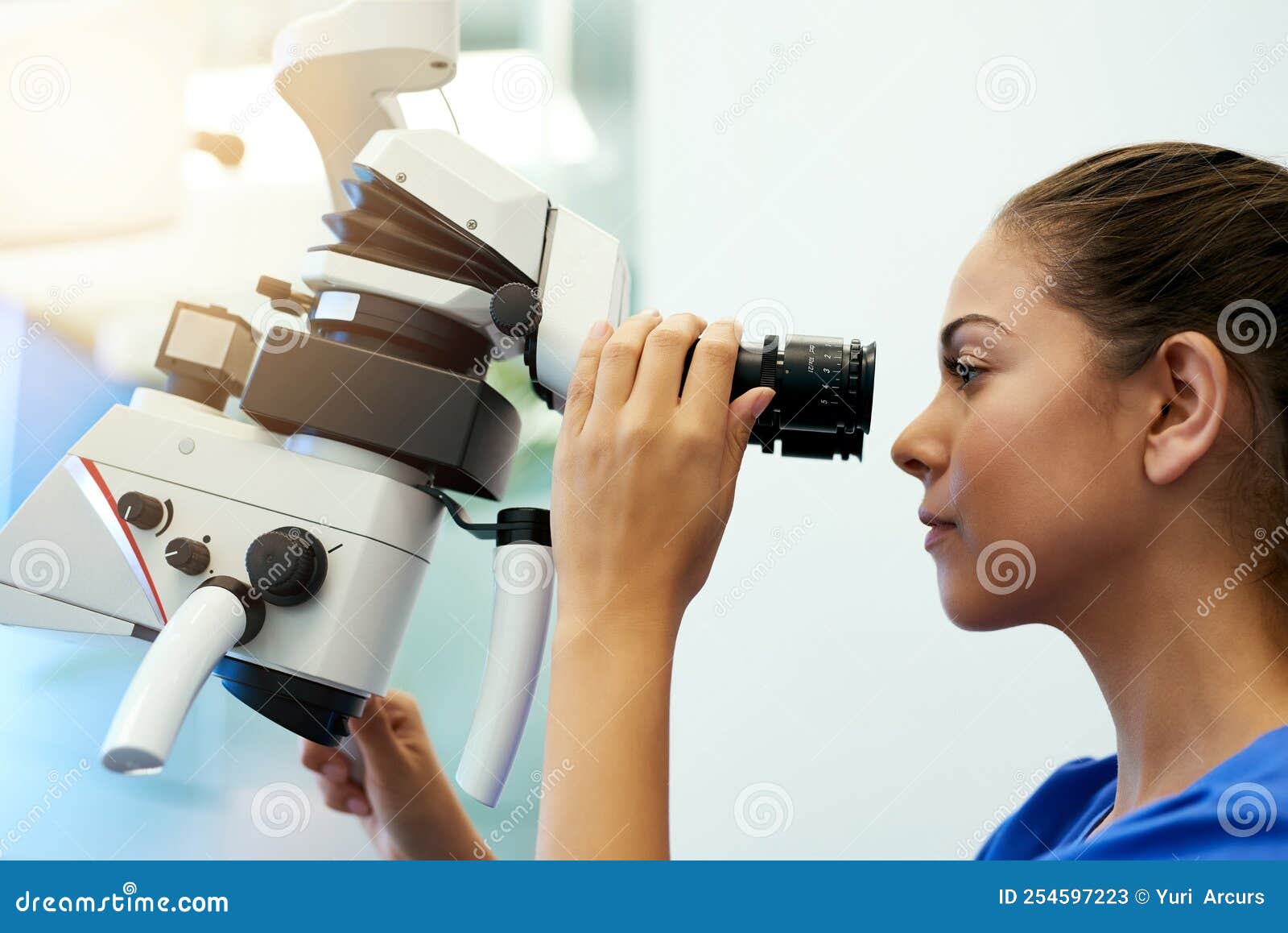 Samples Under Scrutiny. a Young Pathologist Looking at Samples Under a ...