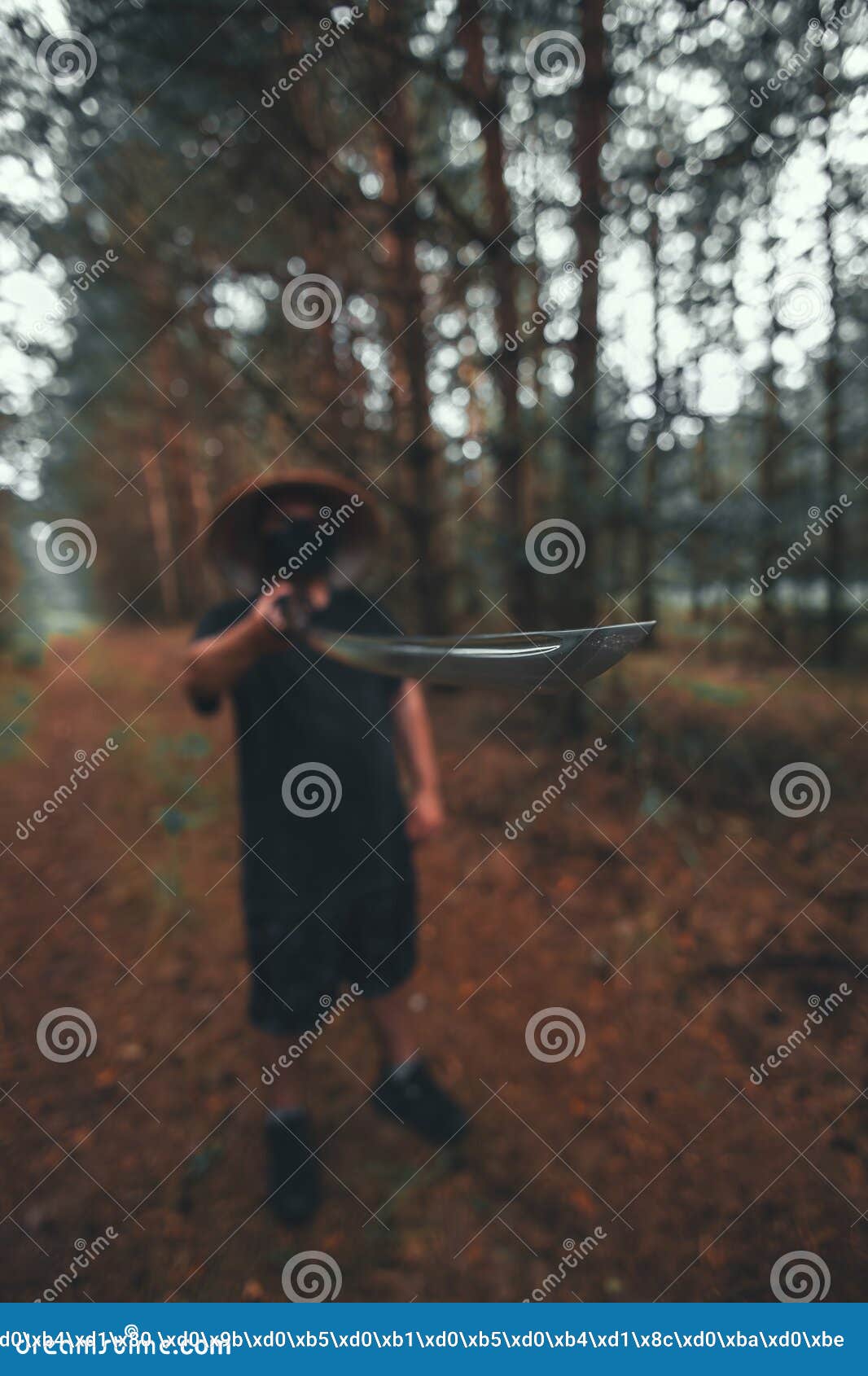 A Samurai in a Straw Hat and Mask Holds a Katana Sword in a Forest. the ...