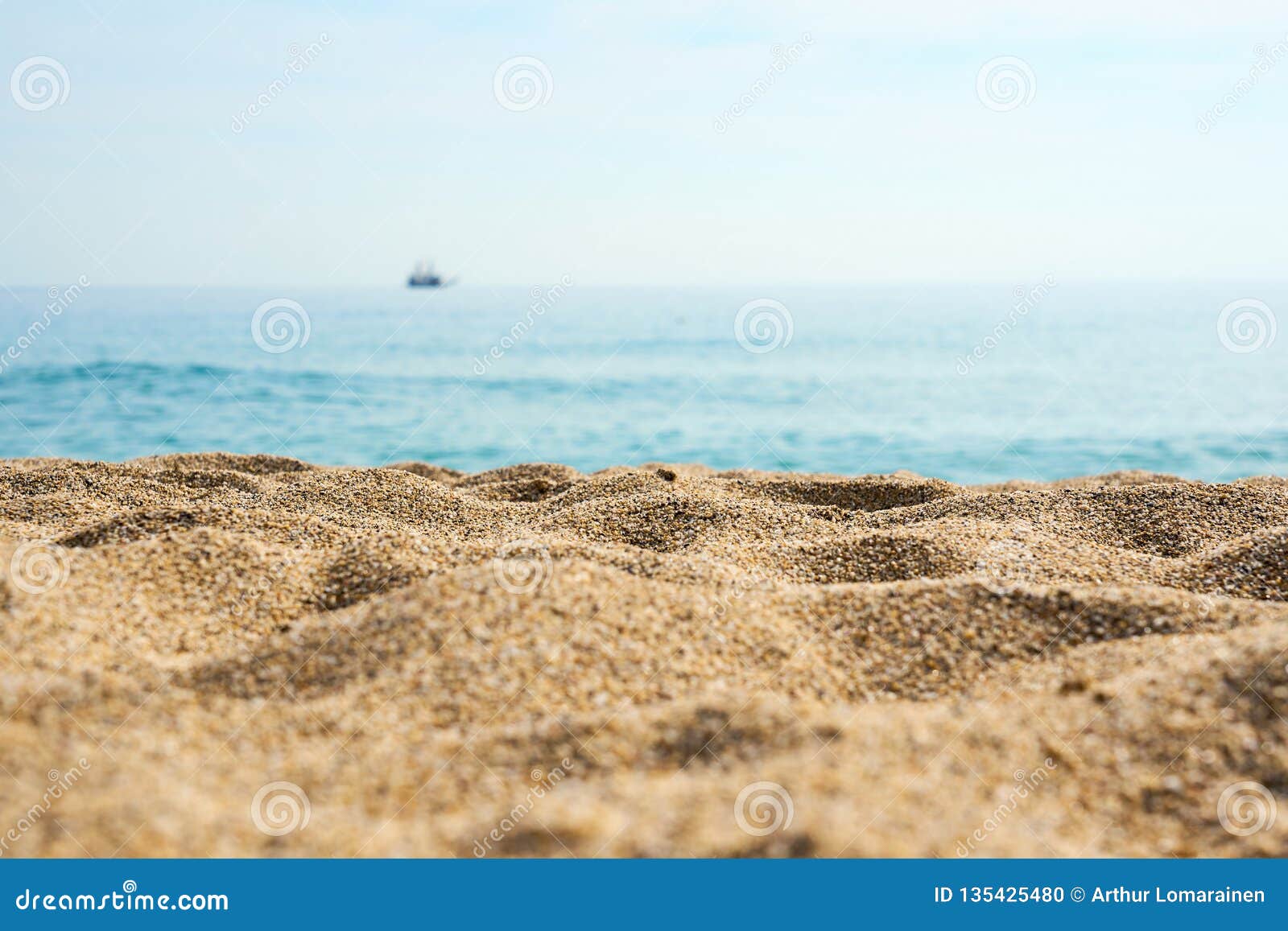 Sand On The Beach Close Up With Blurred Sea, Ship And Waves On A ...