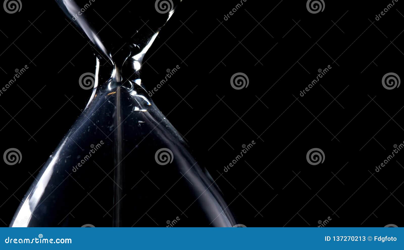 The Sand Flow in the Hourglass with Black Background and Lateral Light ...