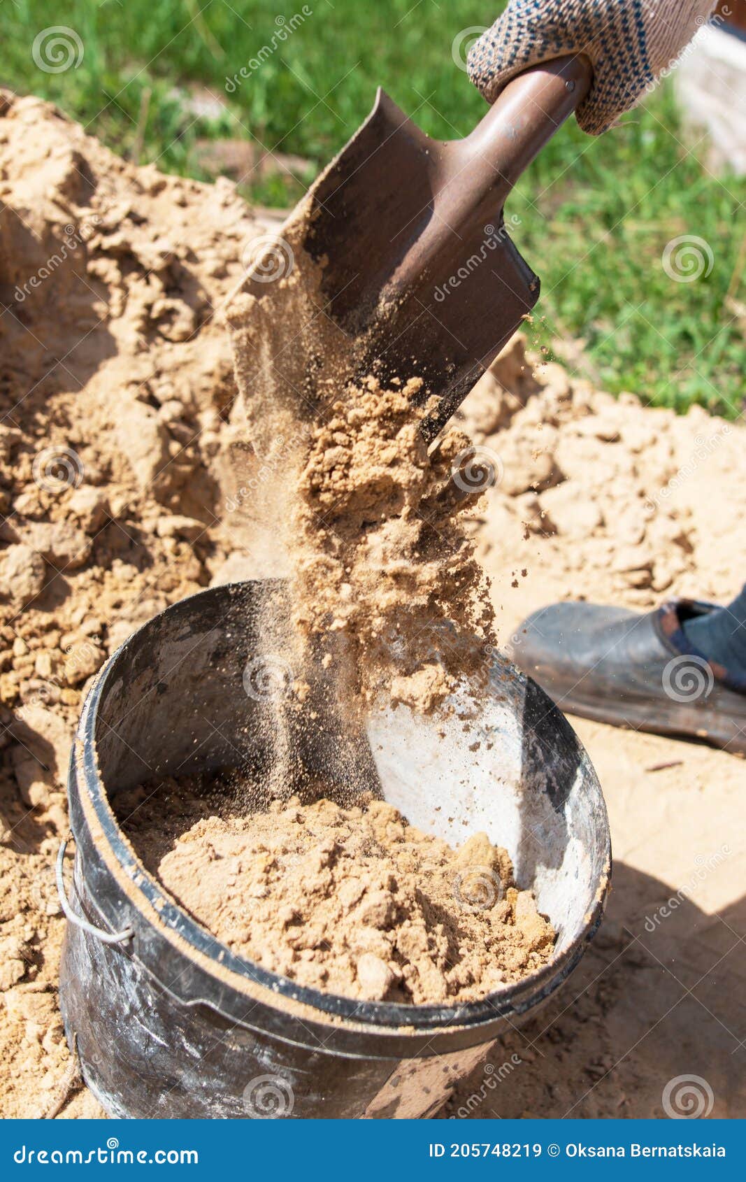 Sand shoveling in a bucket stock image. Image of hands - 205748219