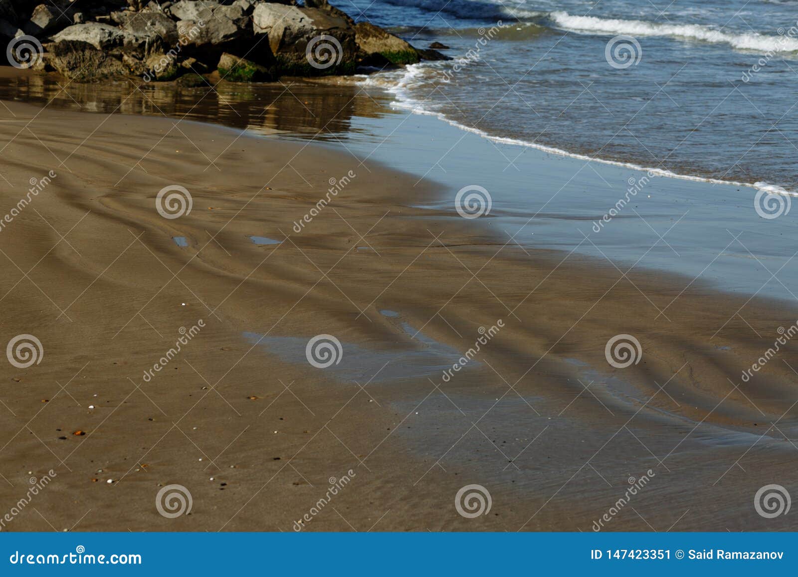 Sand in the Surf on the Background of Coastal Stones Stock Image ...