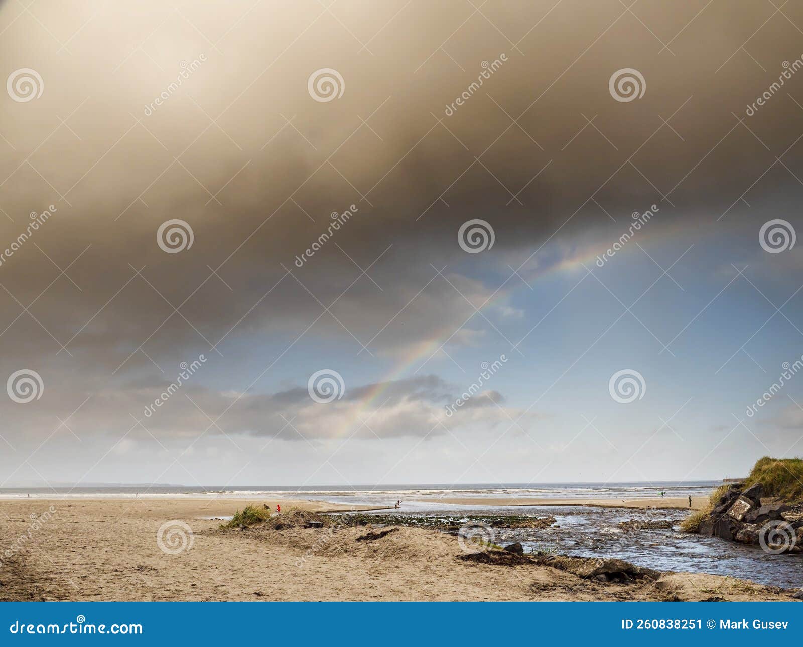 Sandy Beach and Dramatic Cloudy Sky with Rainbow Over the Ocean. Rainy ...