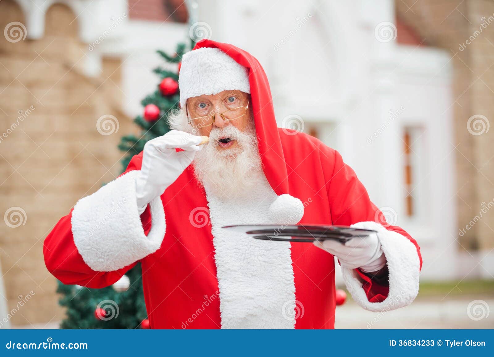 Santa Claus Eating Cookie Against House Imagen de archivo - Imagen de ...