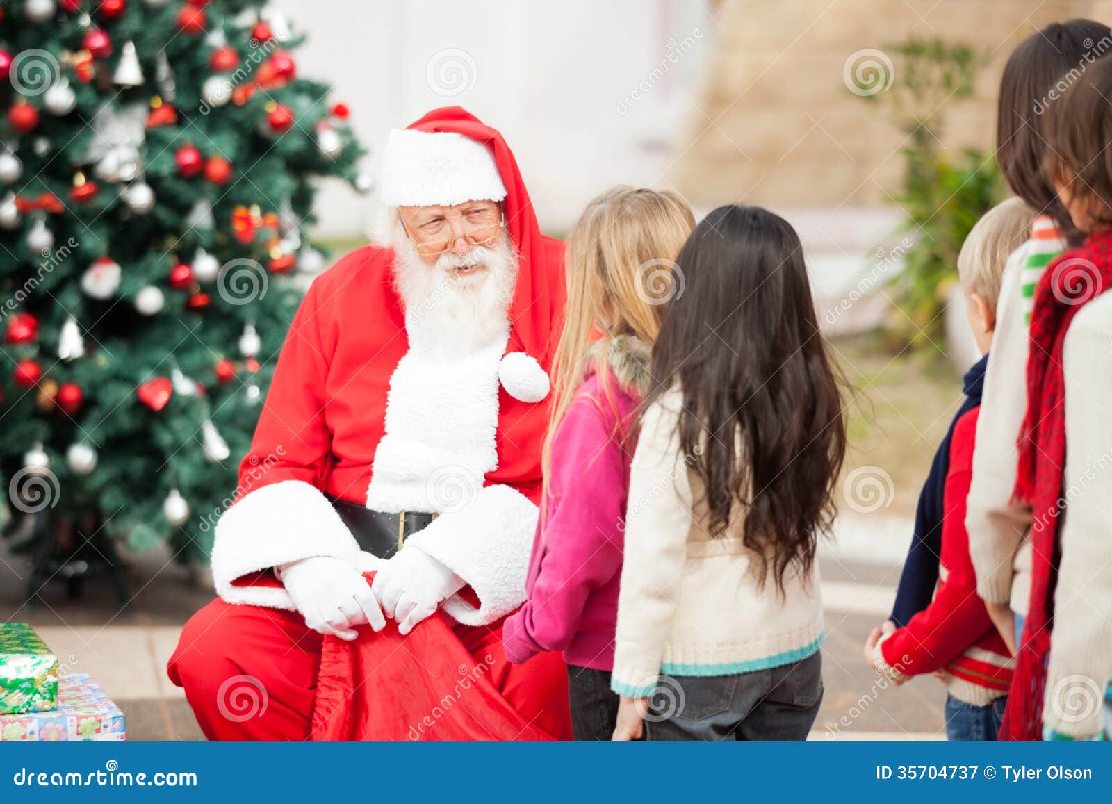 Santa Claus Looking at Children Standing in a Stock Image - Image of ...