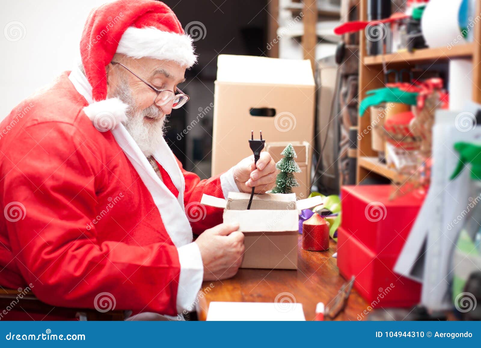 Santa Claus packing a gift stock photo. Image of christmastime - 104944310