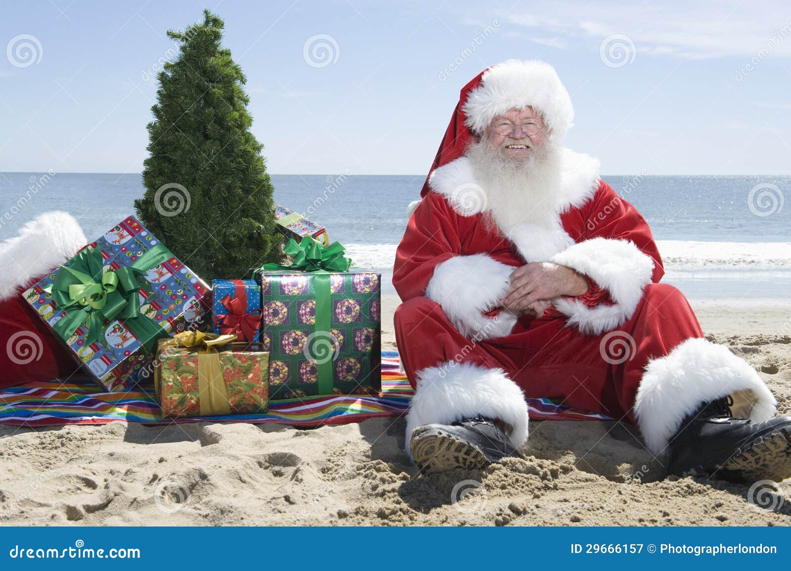 Santa Claus with Presents and Tree Sitting on Beach Stock Image - Image ...