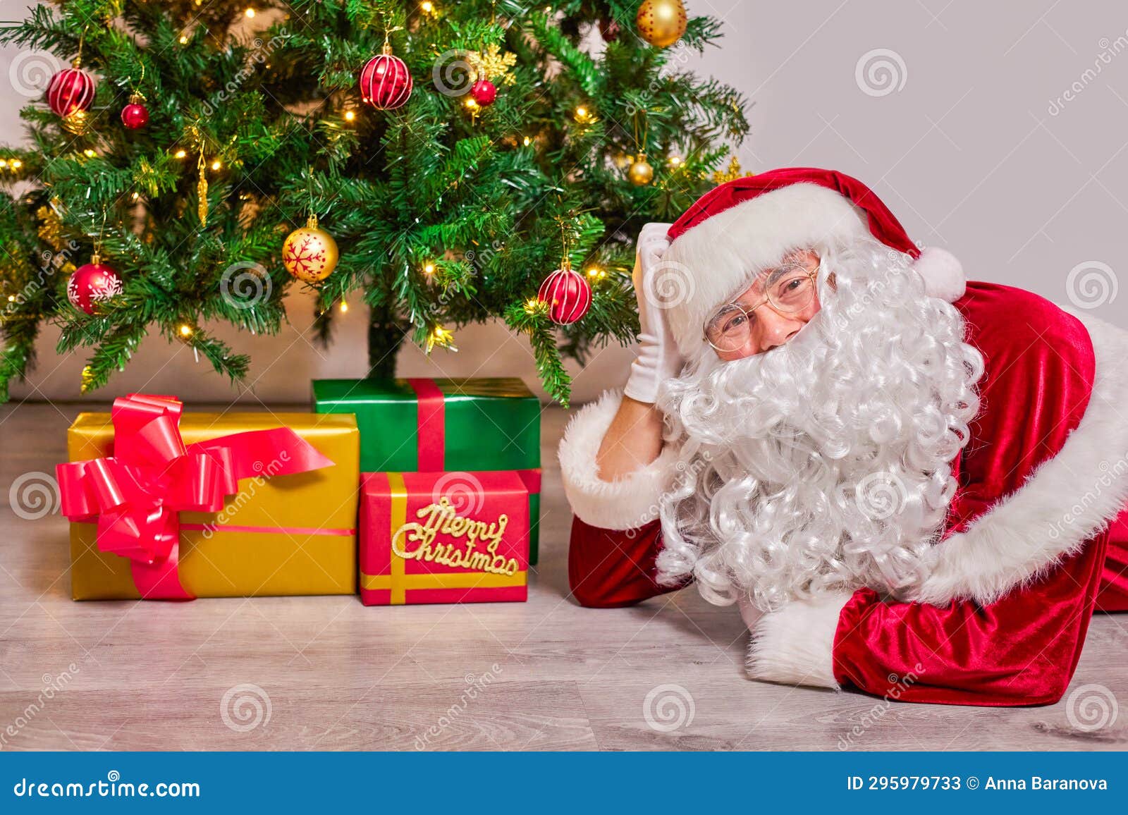Santa Claus Puts a Christmas Gift Under a Decorated Christmas Tree ...