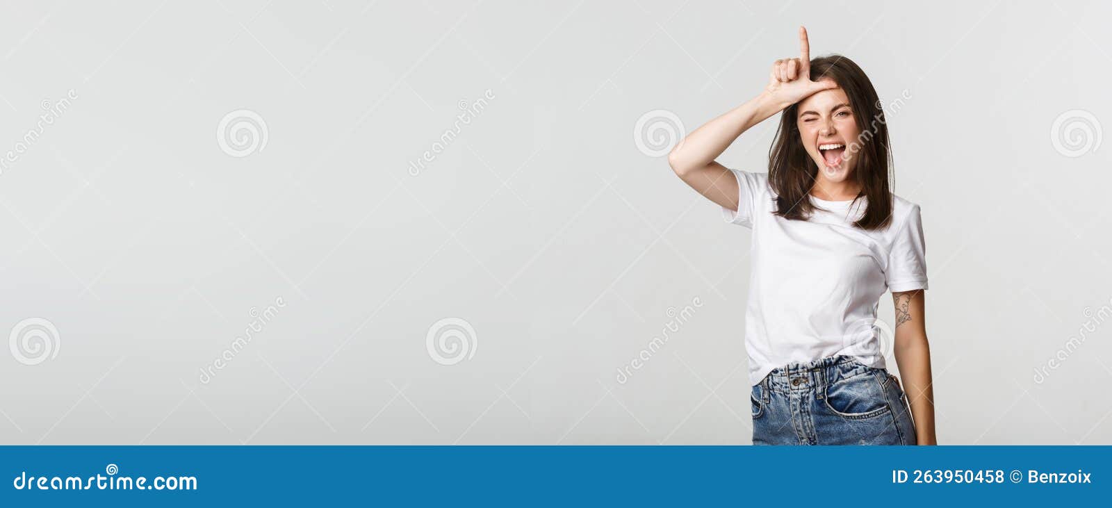 Sassy Good Looking Girl Smiling And Mocking Person Showing Loser Gesture On Forehead Stock