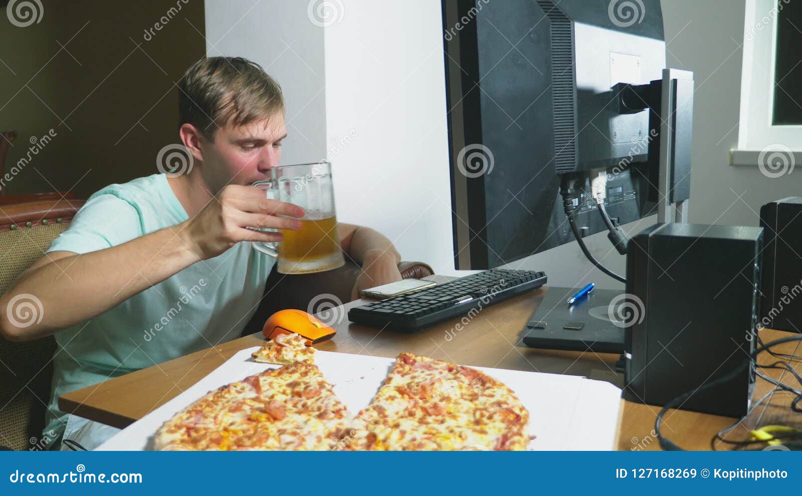 A Satiated Man Sits on the Couch at Home, Drinks Beer and Eats Pizza ...