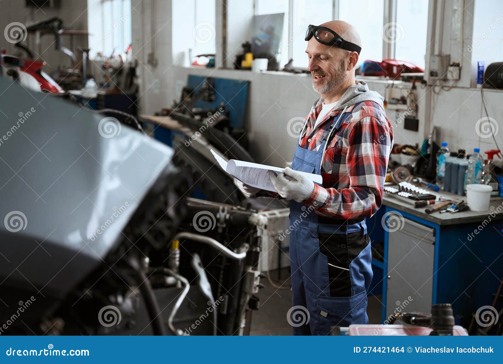 Satisfied Man Stands in Workshop with Working Documentation in His ...