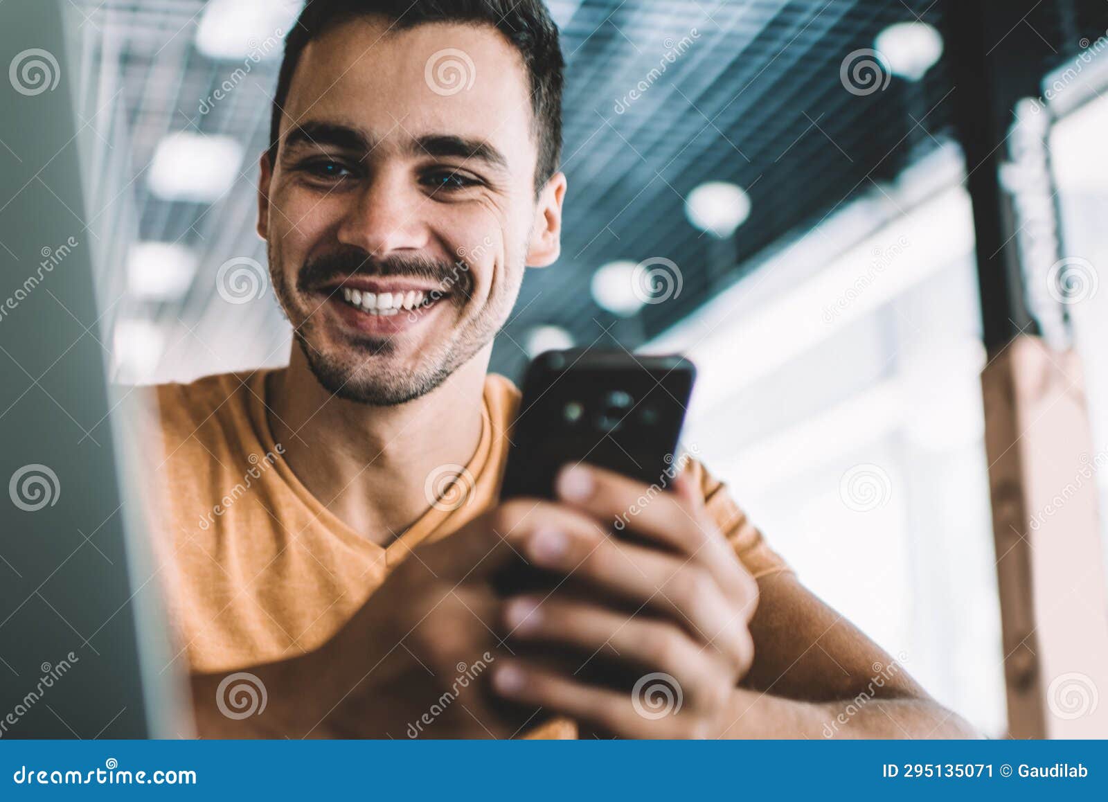 Satisfied Remote Worker Messaging on Phone Watching Laptop at Workplace ...