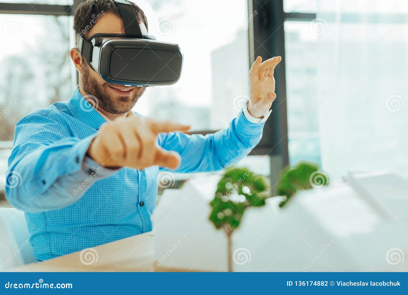 Clever Engineer Smiling and Pointing To Miniature Trees Stock Photo ...