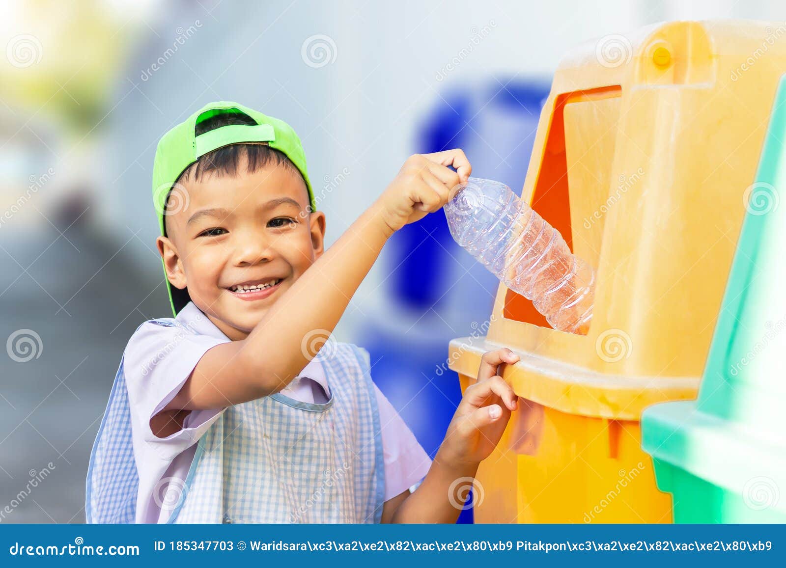 A Child Boy Throwing a Plastic Bottle into a Recycle Bin Stock Image ...