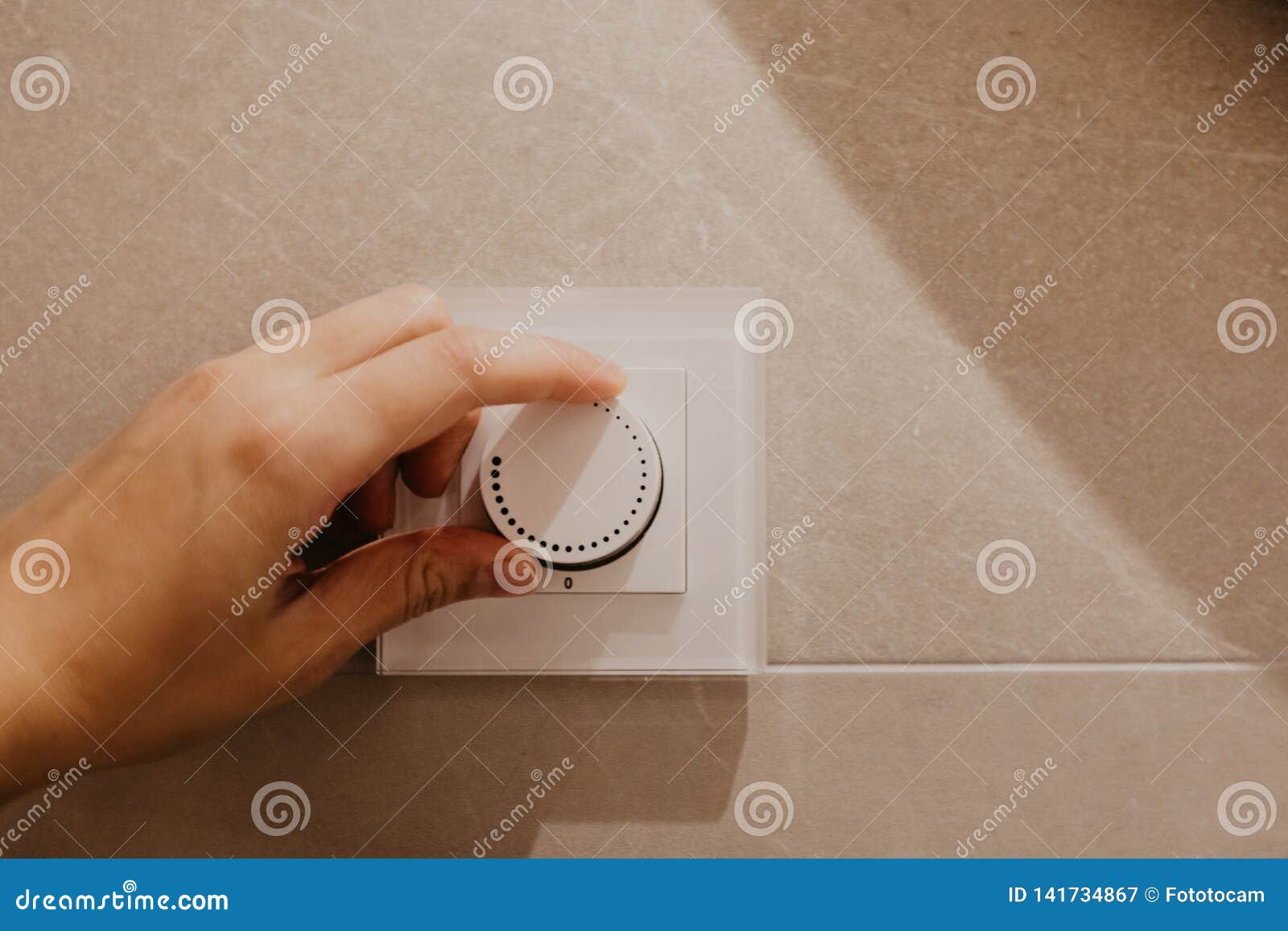 Saving Energy Concept: Human Hand Turning Down Electrical Light Dimmer ...