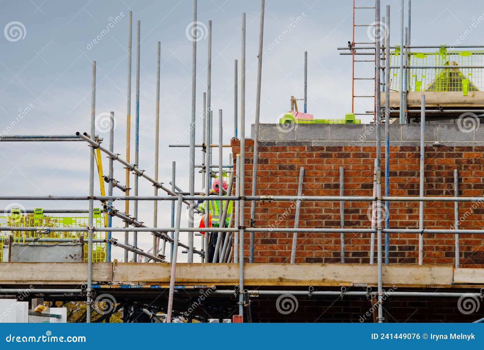 Scaffolder In PPE Erecting Framework Of Wooden Planks And Tall ...