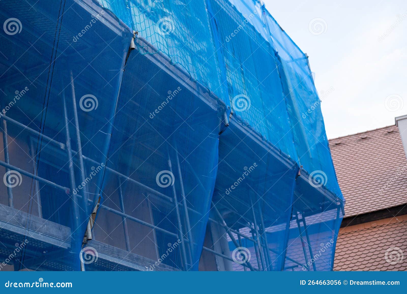 Scaffolding in a Protective Blue Grid. Building Work. Home Construction ...