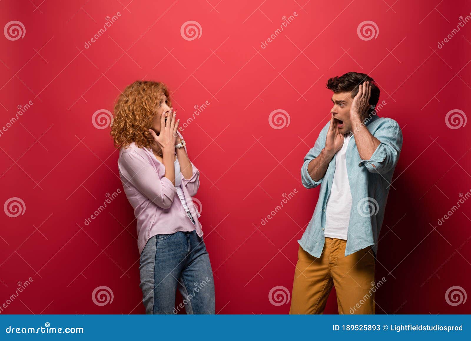 Scared Couple Looking at Each Other, Isolated on Red Stock Image ...
