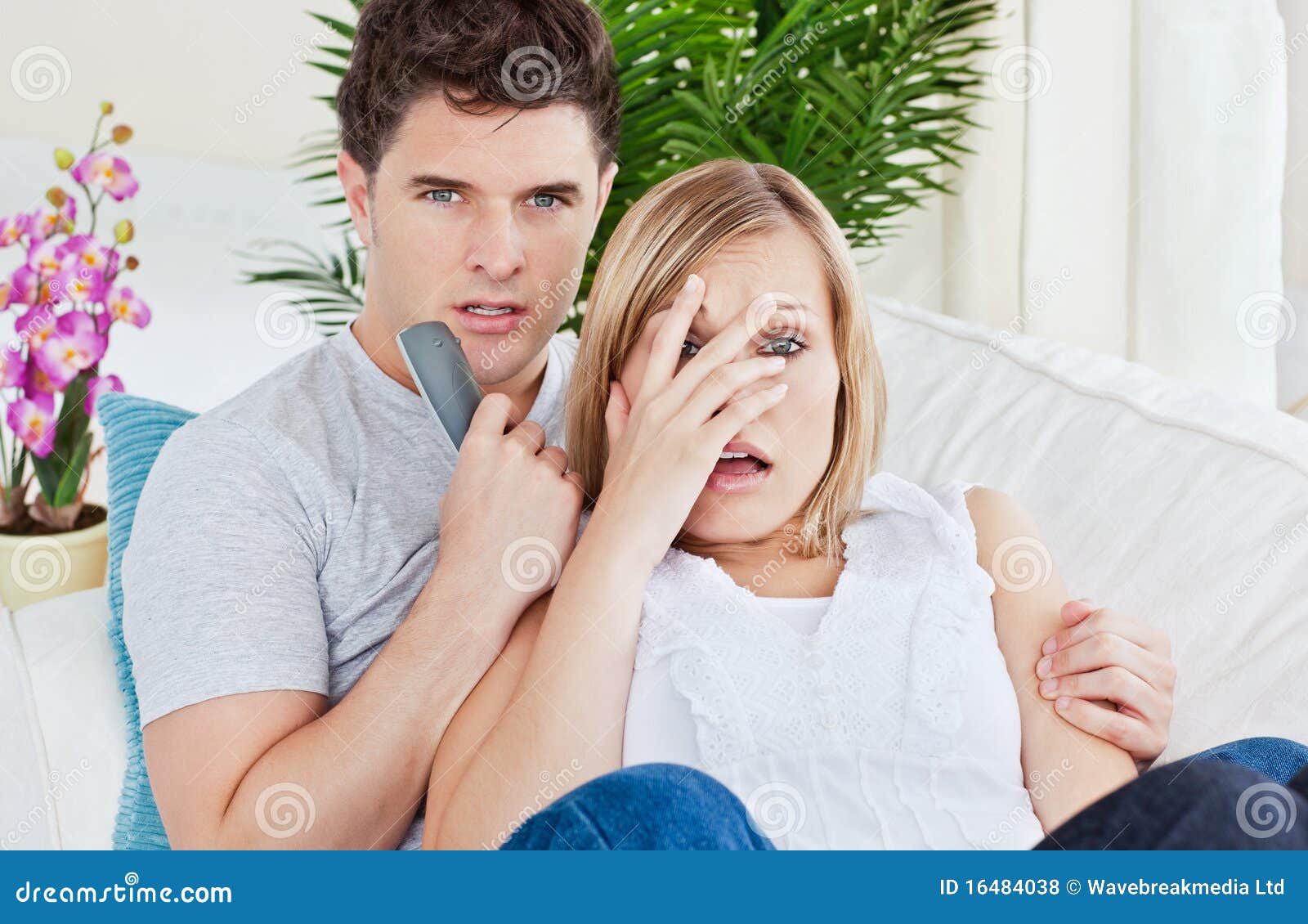 Scared Couple Watching Horror Movie Lying on Sofa Stock Photo - Image ...