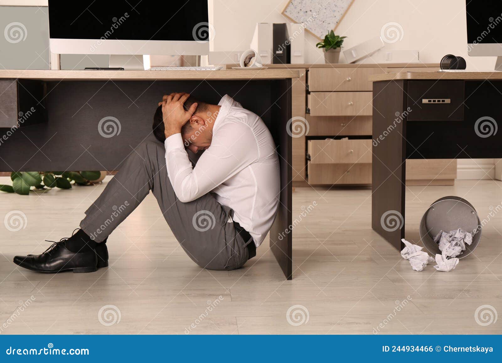 Scared Man Hiding Under Office Desk during Earthquake Stock Photo ...