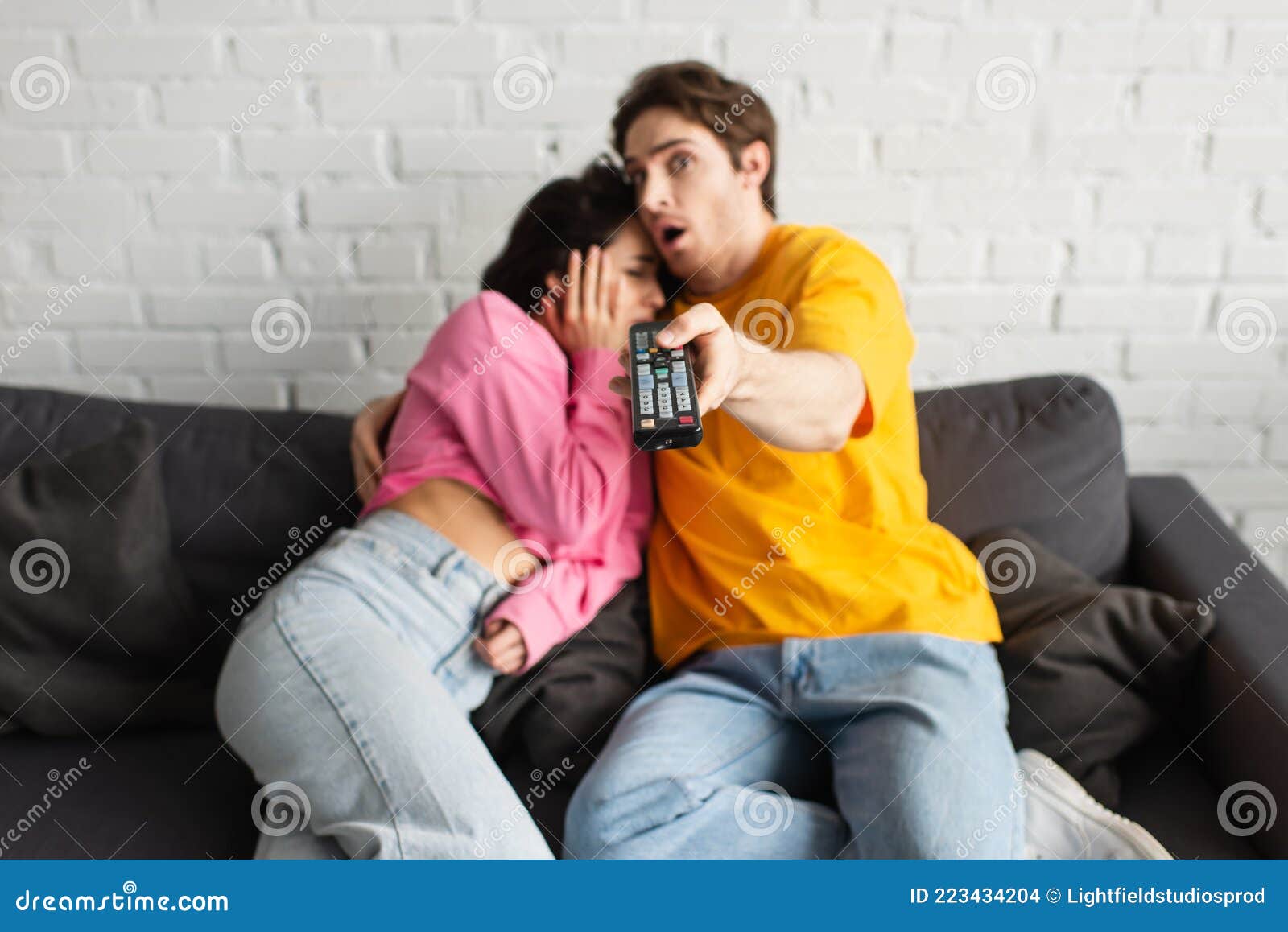 Scared Young Man Pointing with Remote Stock Photo - Image of boyfriend ...