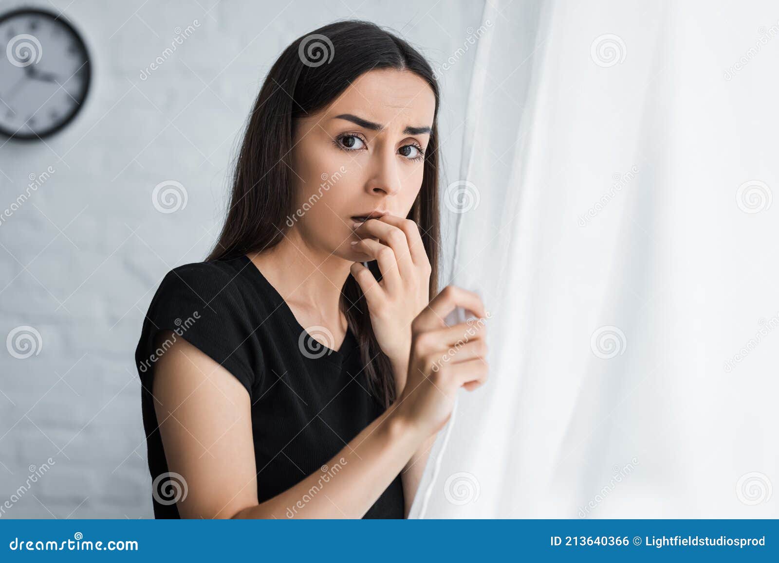 Scared Young Woman Looking at Camera while Standing by Window and ...