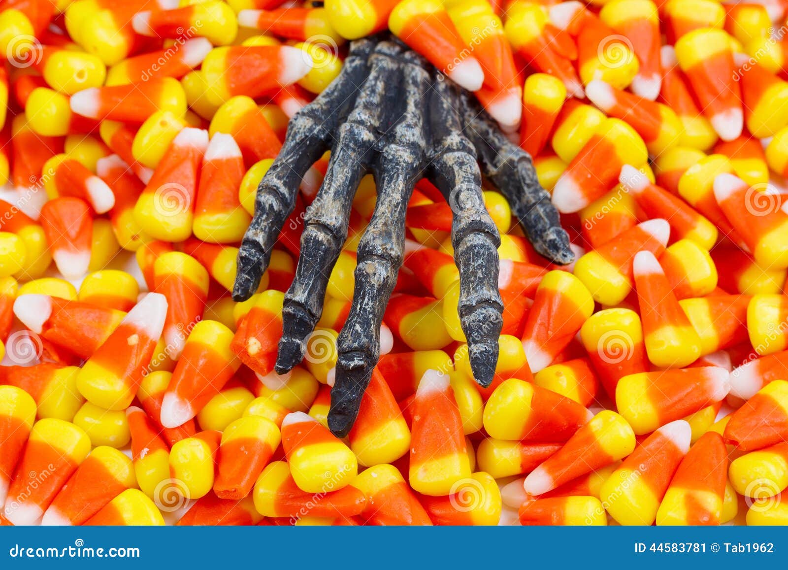 Scary Skeleton Hand Coming Out of Pile of Candy Corn Stock Image ...