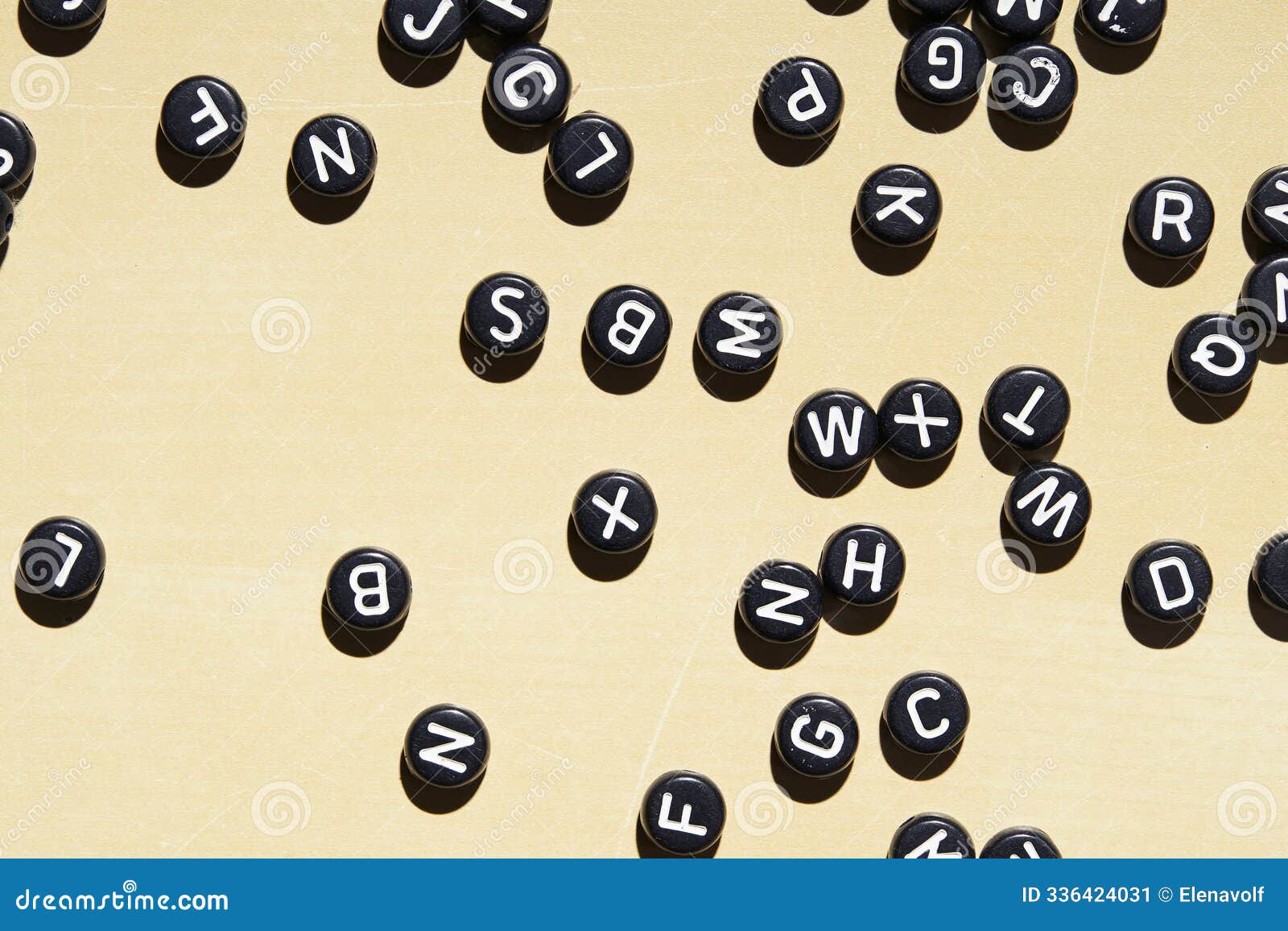 Scattered Black Alphabet Letters on Beige Surface with Randomized Flat ...