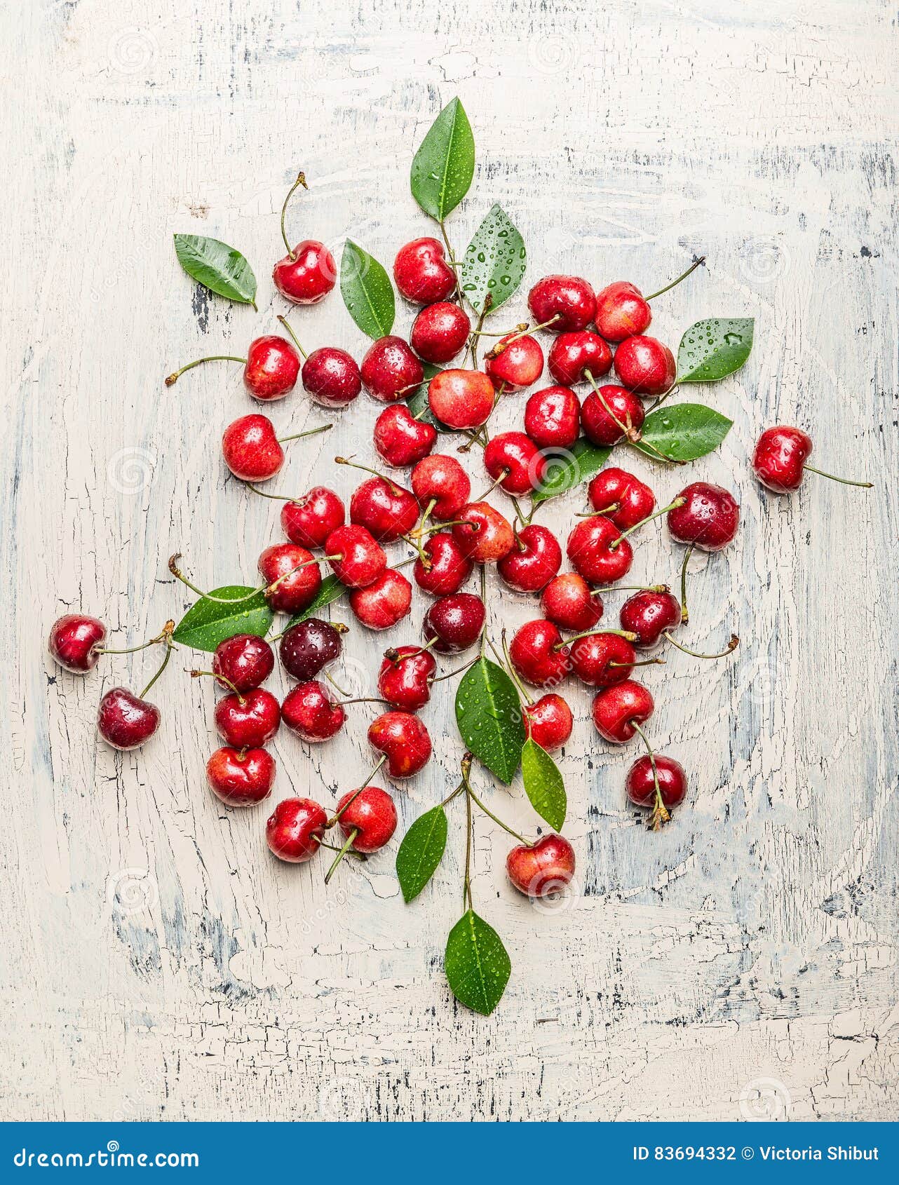Scattered Cherry Berries with Green Leaves on Light Rustic Background ...