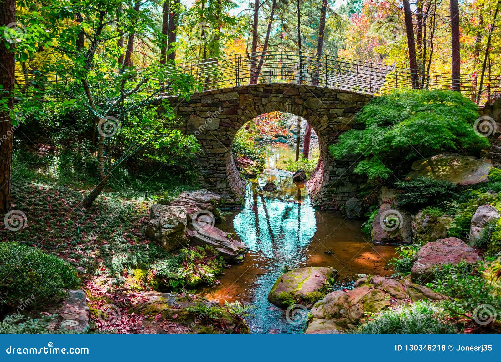 Scenic Round Stone Bridge Over a Stream with Fall Colors Emerging Stock ...