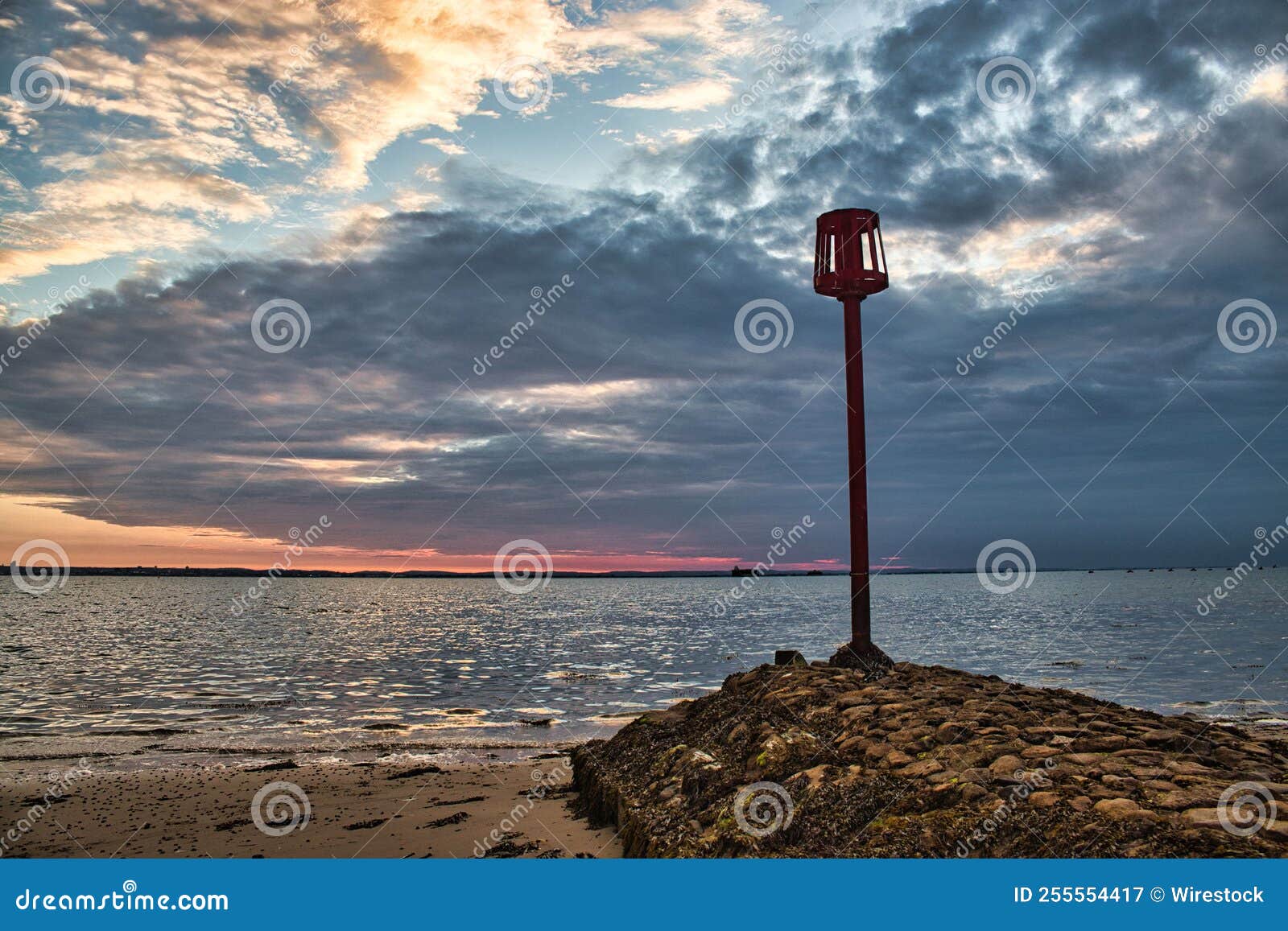 Scenic Shot of a Red Stand for Fire at a Beach with a Sunset Cloudscape ...