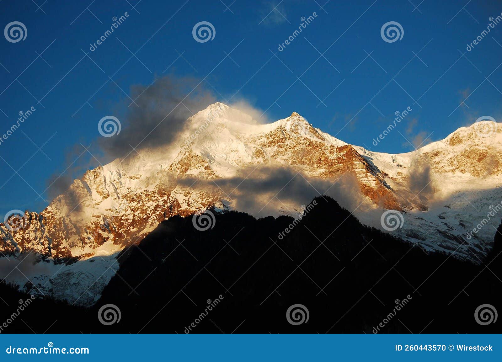 Scenic Shot of Snowy Mountains Covered with Clouds Under the Sunlight ...