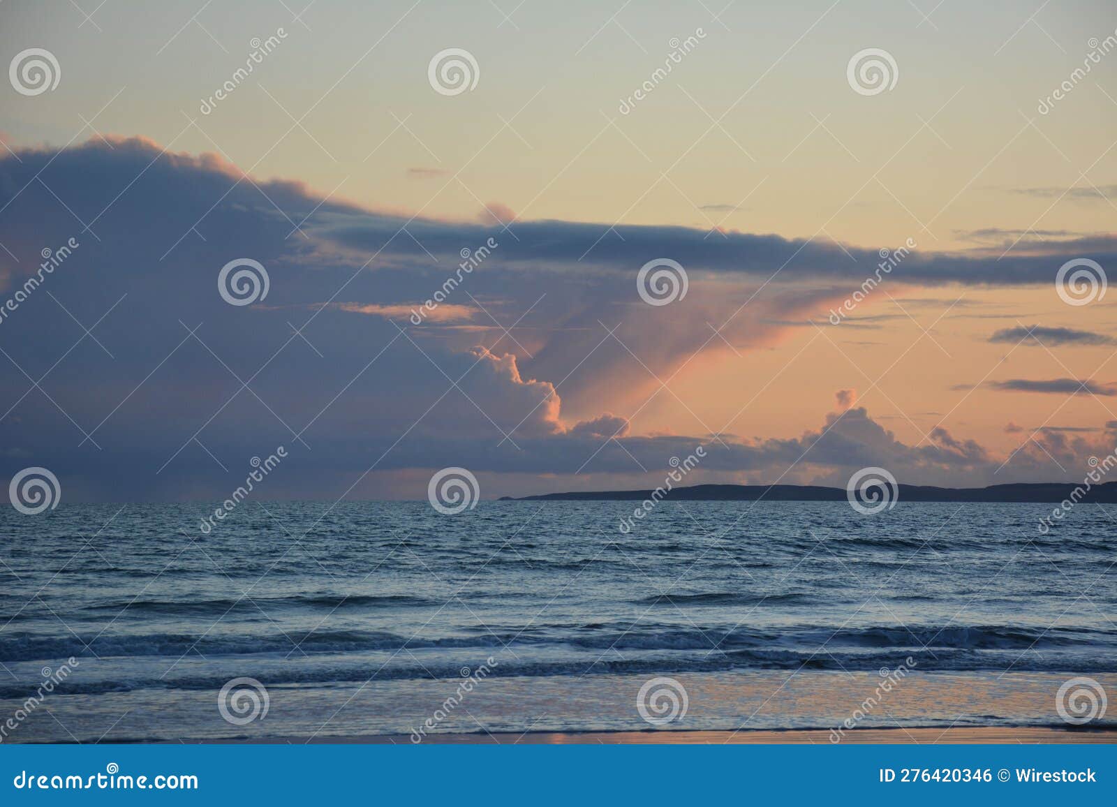 Scenic View of a Cloudy Sky and Blue Ocean with the Sun Setting in the ...