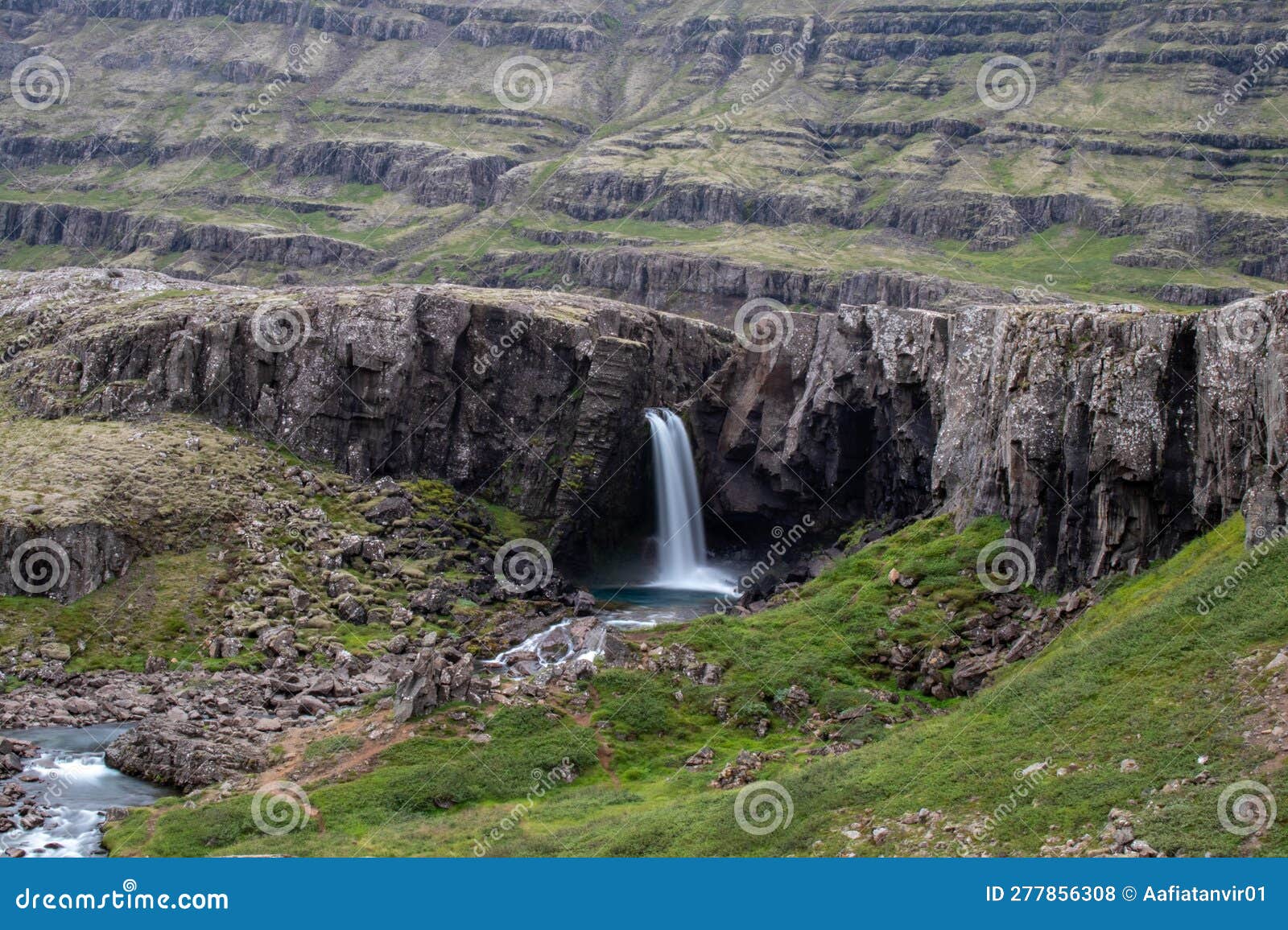 Scenic View of a Distant Waterfall Flowing between Green Cliffs in ...