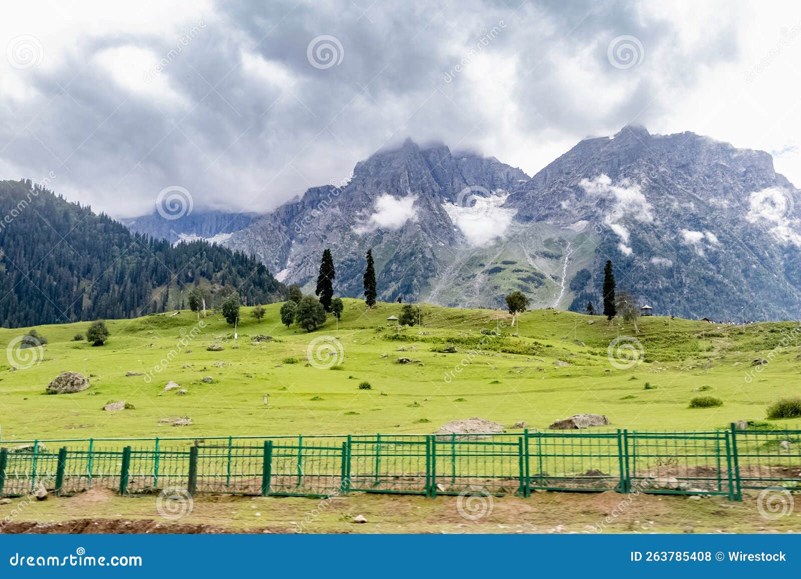 Scenic View of a Mountain Range Covered with Greenery Behind a Fence in ...