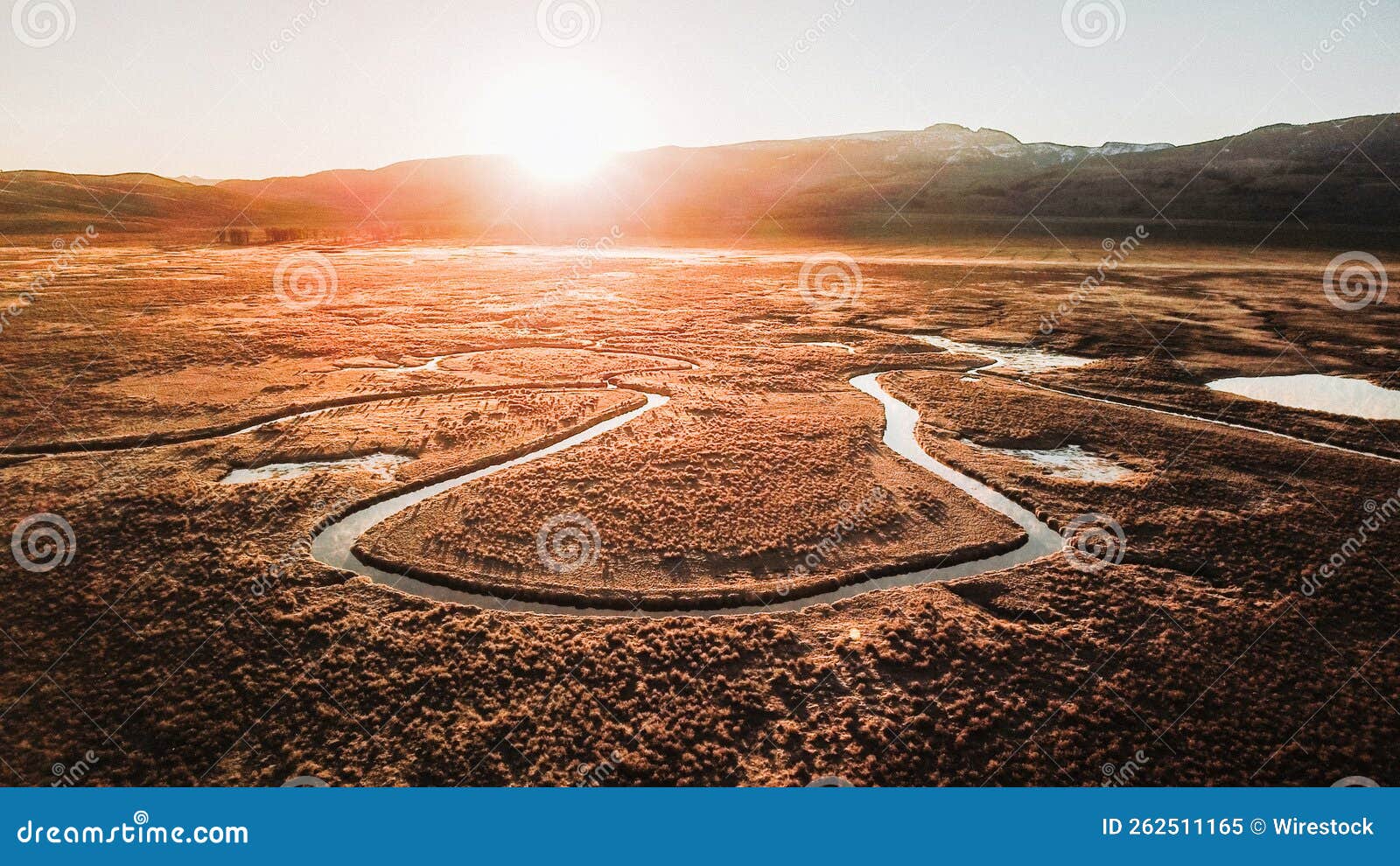 Scenic View of a River Flowing through Fields on a Mountainous ...