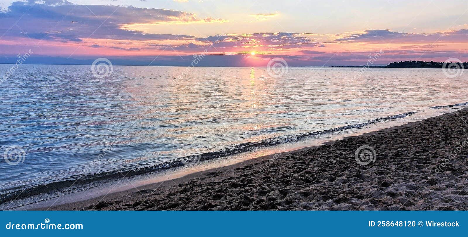 Scenic View of a Sea Shore at Sunset with the Sun Reflecting on the ...