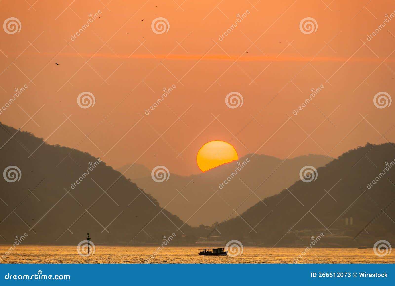 Scenic View of a Sunrise Behind a Mountain Range, and a Boat on the ...
