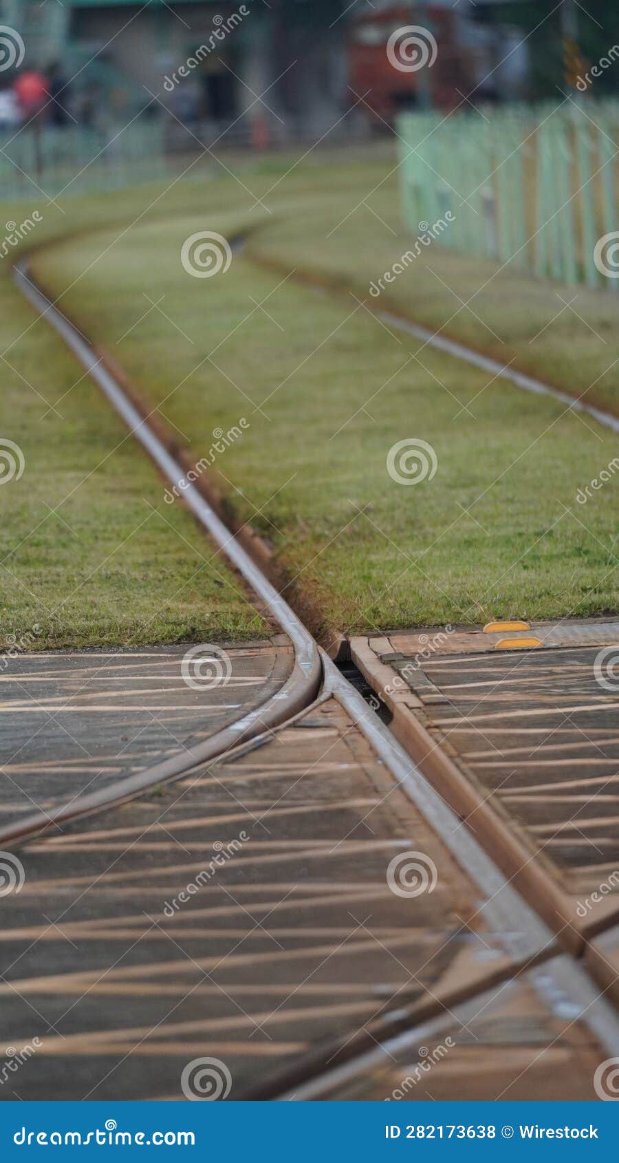 Scenic View of a Train Track Running Alongside a Green Grassy Field ...